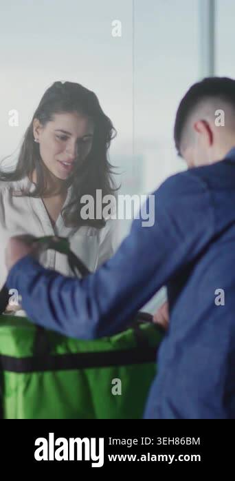 office caucasian woman opening paper bag and inspecting delivered meal ...
