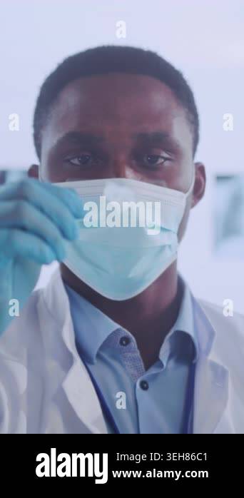 black scientist holding specimen slide to camera with gloved hands ...
