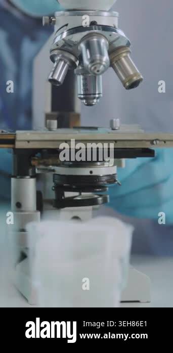 Closeup microscope objectives on stage, sterile slide holder, blurred ...