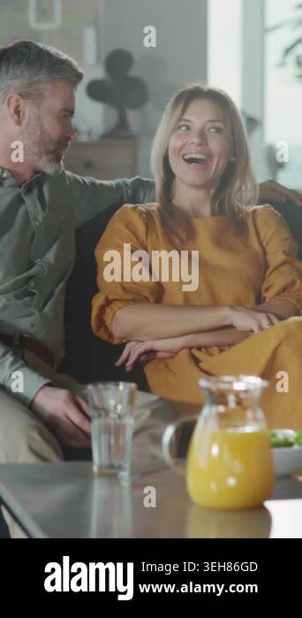 caucasian woman laughing with husband, tulips, modern living room ...