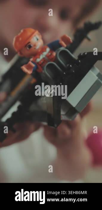 child assembling toy vehicle and figure, closeup of small plastic ...