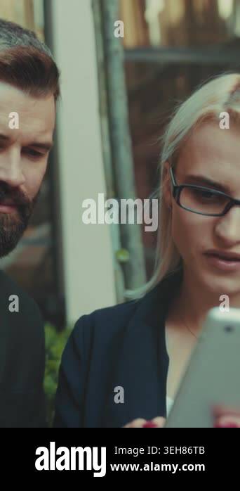 White colleagues study tablet screen outdoors. Bearded male executive ...