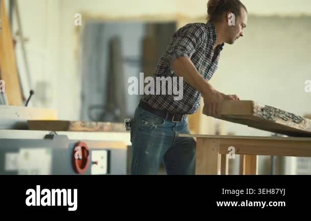 Professional craftsman processing a wooden plank with an industrial ...