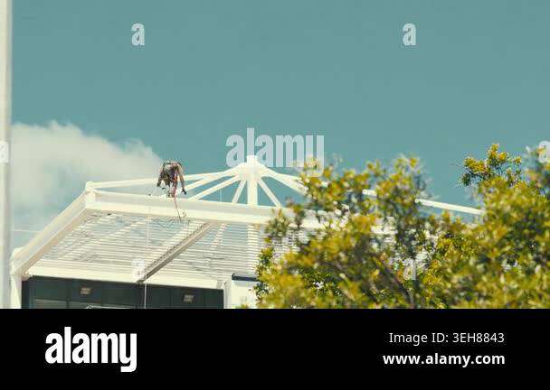 15 may 2026, Lisbon, Portugal - A worker is seen climbing down the roof ...