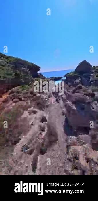 View the aerial drone perspective of Sfakia Beach. Observe the rocks ...