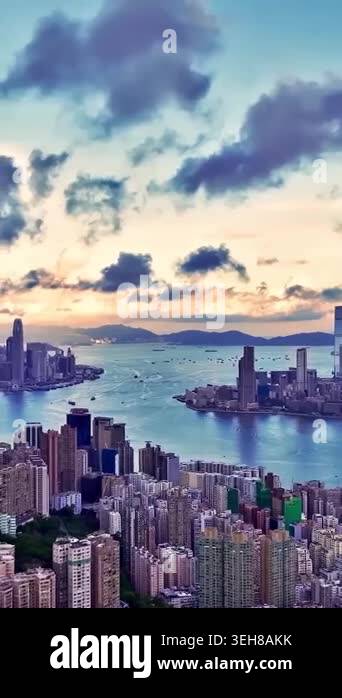 A drone shows the skyline of Hong Kong at sunset. The city lights begin ...