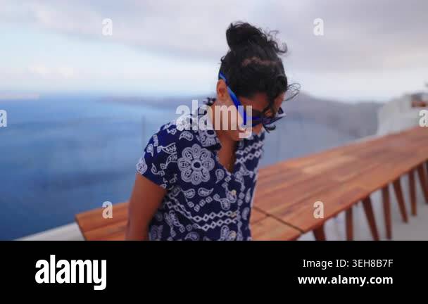 Joyful Indian young woman wearing blue sunglasses and patterned shirt ...
