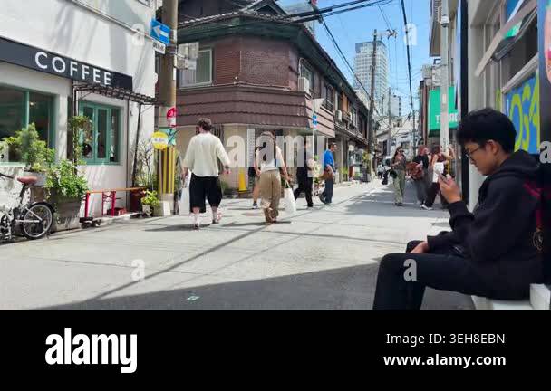 OSAKA, JAPAN - APRIL 18, 2026: People walk down a narrow shopping ...