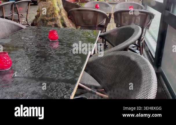 Empty cafe open terrace under spring rain, water droplets fall on wet ...