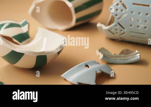 Ceramic pieces are scattered on a table after an accident in the ...