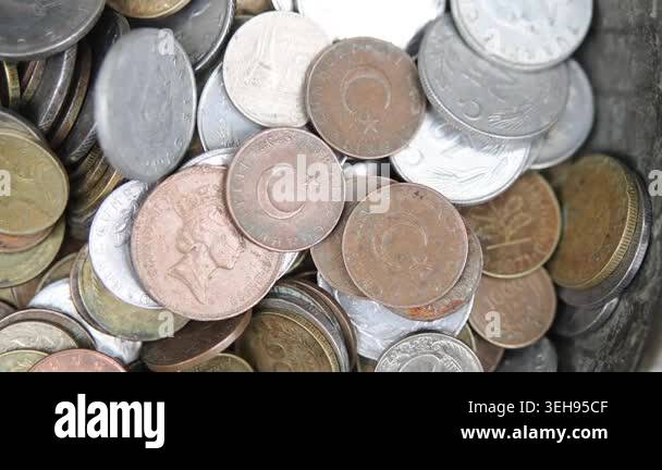 A close view of various coins from multiple countries in a bowl Stock ...