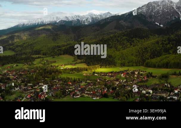 Scenic mountain village with traditional houses in green alpine valley ...