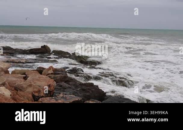 Powerful sea waves crashing against rocky Mediterranean shoreline in ...