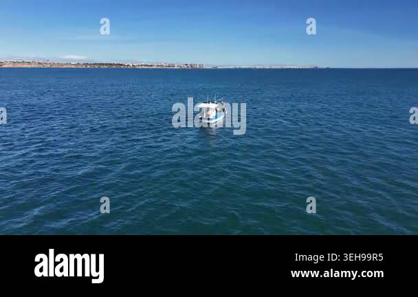 Drone aerial view of small fishing boat floating on calm Mediterranean ...