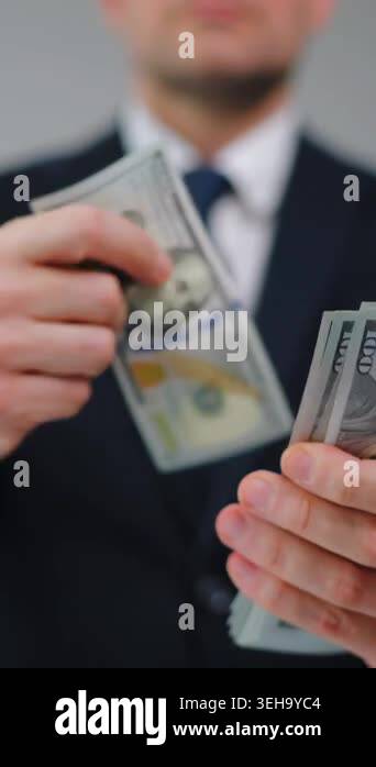 Formally dressed man carelessly throws US Dollar bills towards the ...