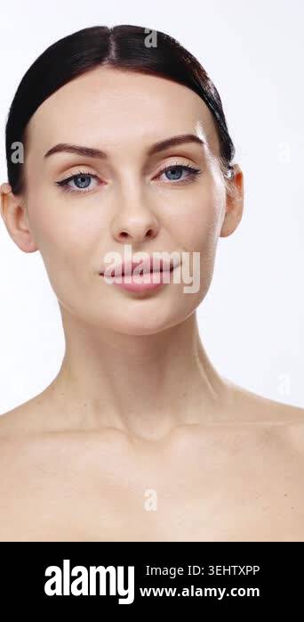 Young woman with clean skin posing against a plain white background ...