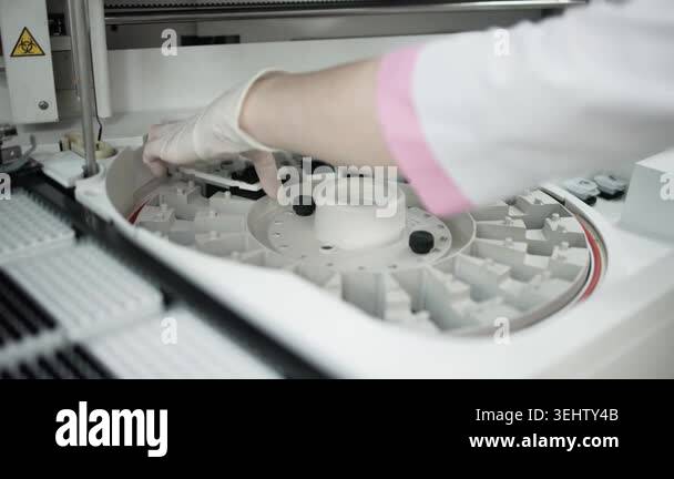 Person wearing gloves operating equipment in a laboratory environment ...