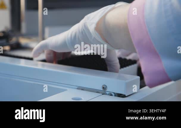 Person wearing a glove adjusting equipment in a laboratory setting ...