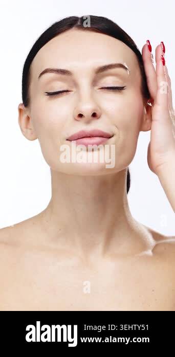 Woman with closed eyes touching her face in a serene skin care setting ...
