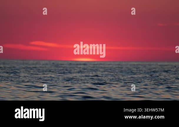 Beautiful pink sunset over calm sea, relaxing waves and soft light ...