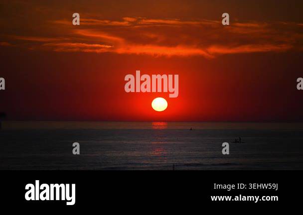 Spectacular evening sky and golden sun over still ocean water, peaceful ...