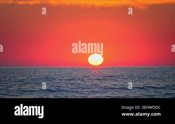 Beautiful sunset above tranquil sea with warm colors and gentle waves ...