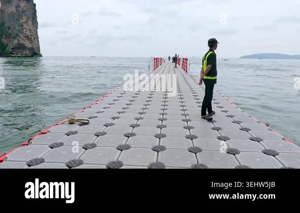 Person standing on a floating dock overlooking the water on a cloudy ...