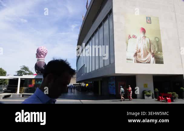 Silhouette of a person walking past a modern building with large ...