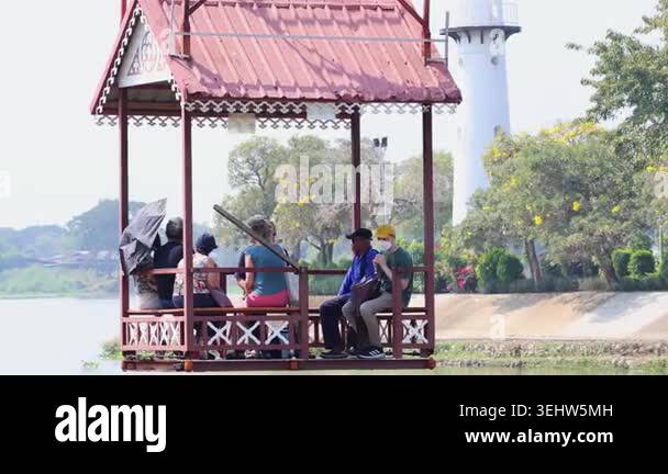 Group of people sitting in a gazebo at a park with trees and a ...