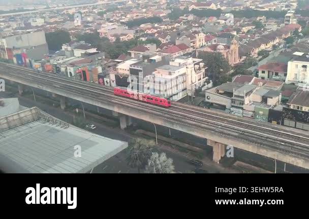 JAKARTA, INDONESIA - MAY 10, 2026: A red LRT train moving on elevated ...