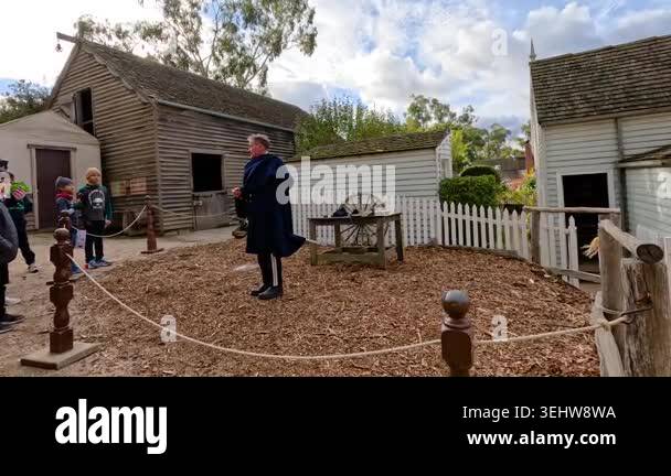 Middle-aged man standing in a historical outdoor setting near wooden ...