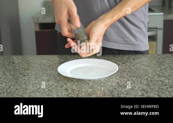 Close up man grinding black pepper with manual pepper mill with clear ...