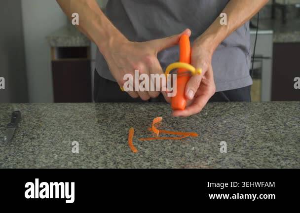 Close up man peeling carrot with vegetable peeler with clear sound ...