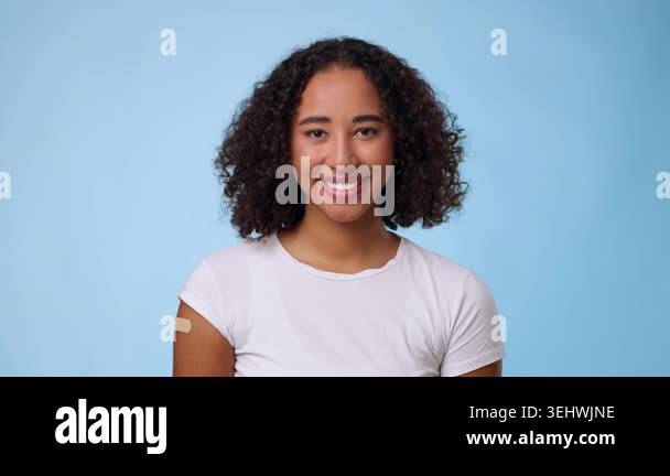 Young African American woman with curly hair smiles confidently after ...