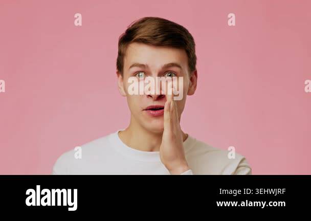 A young man with light skin is leaning slightly forward, cupping his ...