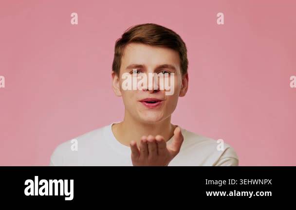 A young man with light skin is sending a kiss gesture towards the ...