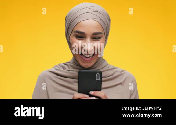 A woman with a headscarf is enjoying a moment as she looks at her ...
