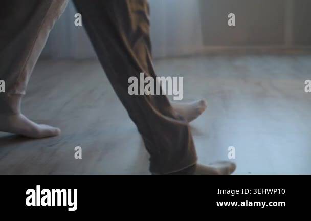 Two dancers are practicing in a well-lit room. The wooden floor is ...