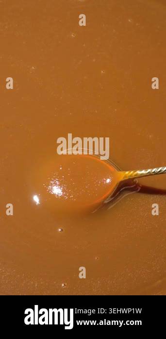 Dessert caramel sauce dripping from spoon, slow motion macro Stock ...