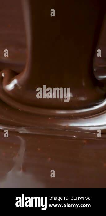 Slow motion vertical pour of melted chocolate dessert topping Stock ...