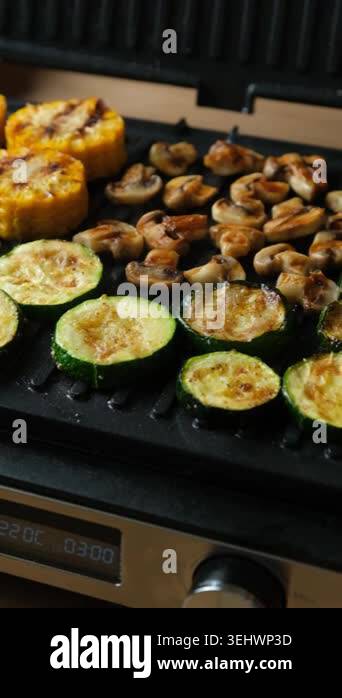 Cooking Corn, Zucchini, and Mushrooms Together on Home Grill Plate ...