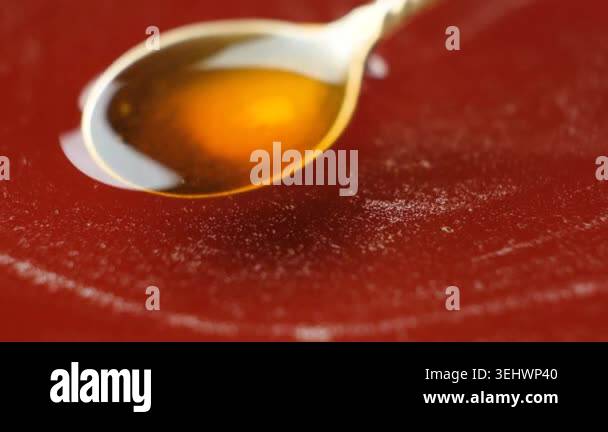 Macro slow motion of natural maple syrup dripping from spoon Stock ...