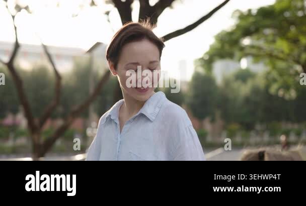 Portrait of happy woman talks to little girl as walks together in sunny ...