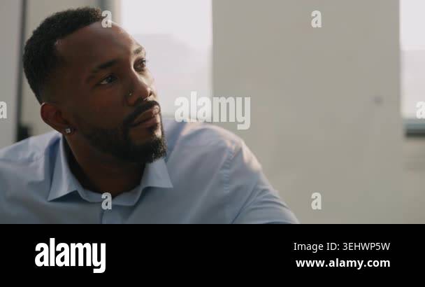 Portrait of young African American businessman in shirt listens to ...
