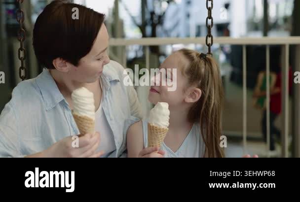 Portrait of happy mother and little daughter eat delicious ice cream in ...