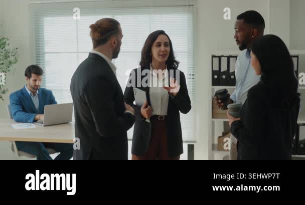 Portrait of young Latin woman boss talks to diverse professionals team ...