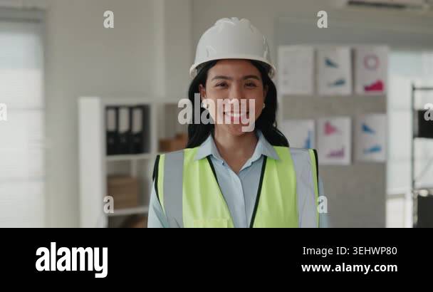 Portrait of Asian lady engineer in hard hat and safety vest in modern ...