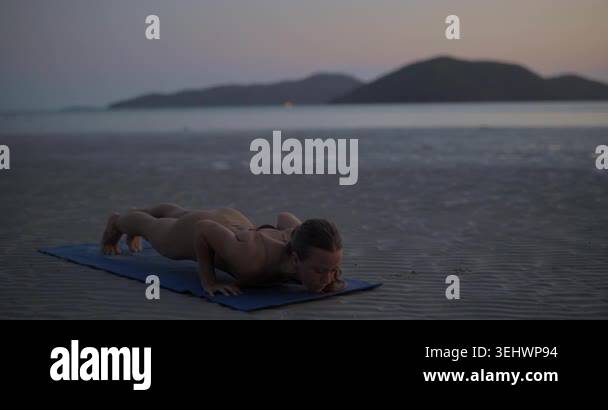 Portrait of flexible woman stands in cobra pose on mat against tranquil ...