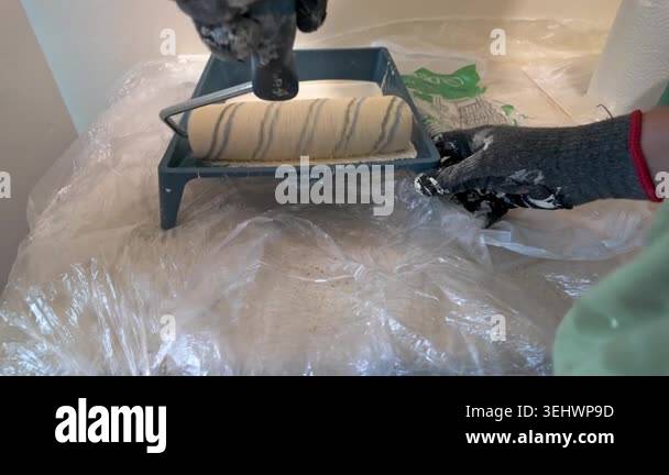 Painter rolling white paint onto roller over tray in room Stock Video ...