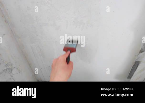 Hand brushing primer onto interior plaster wall in room corner Stock ...